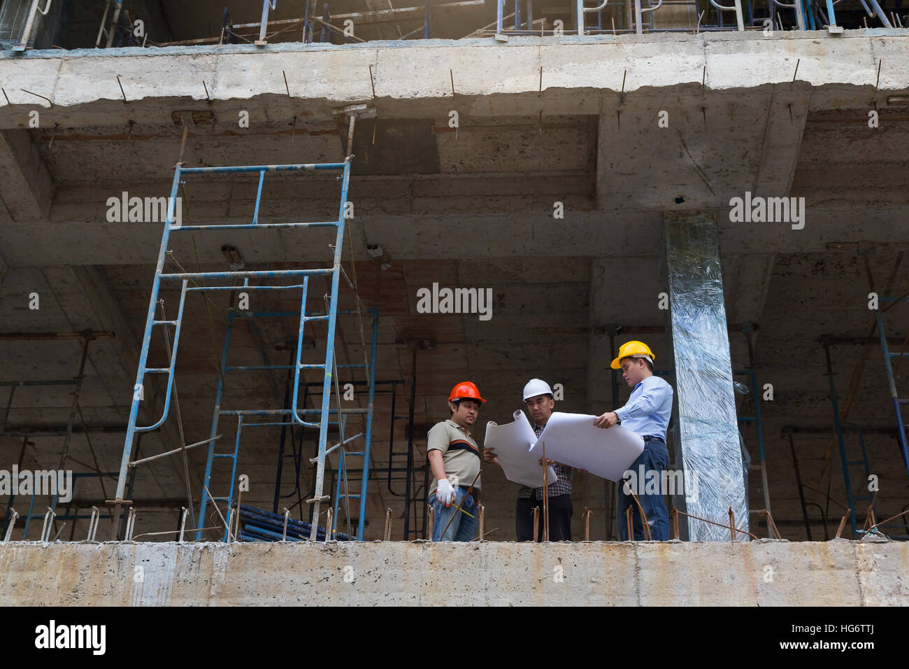 Engineer and Architect working at Construction Site with blueprint ...
