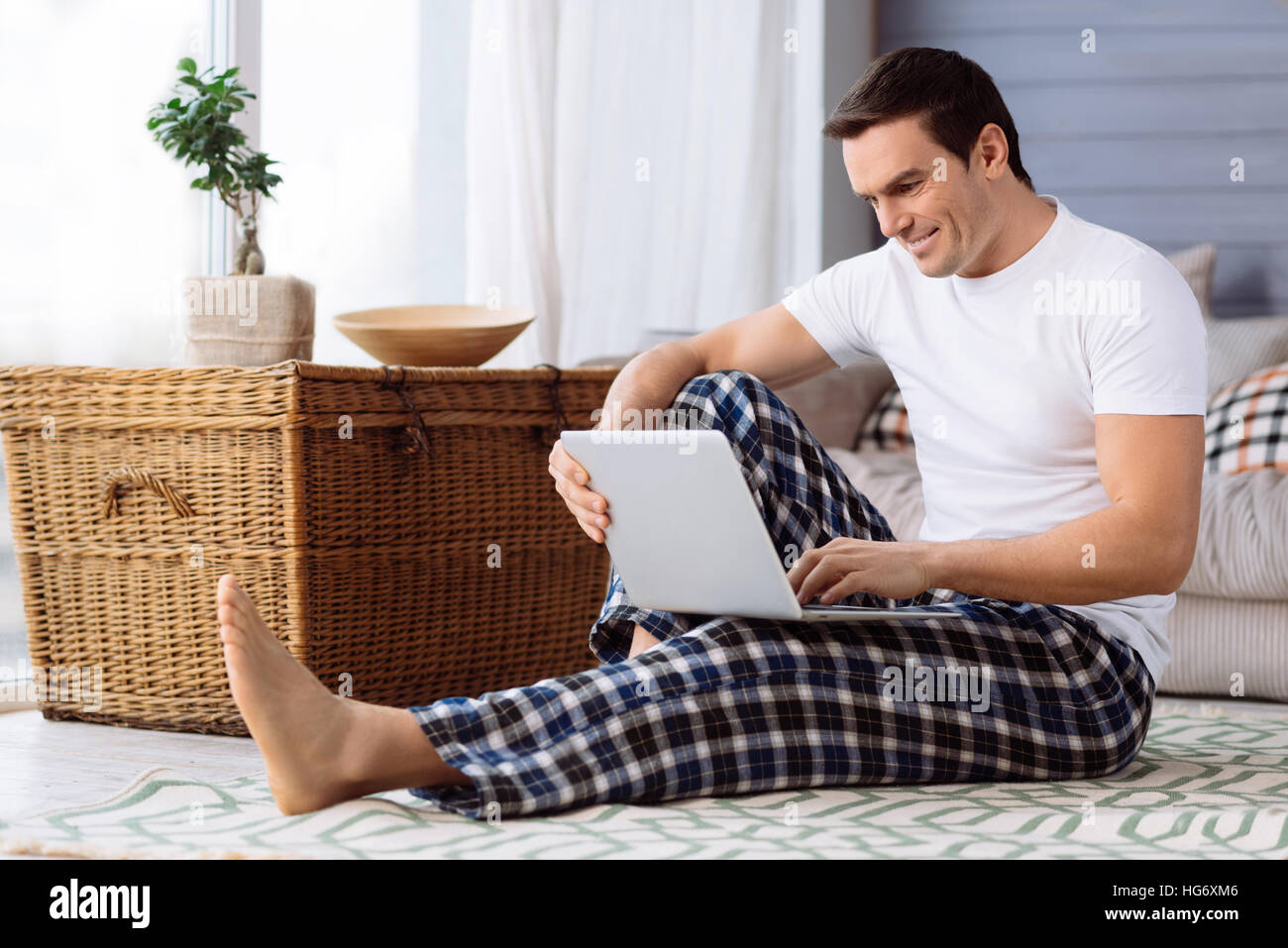 Happy handsome man looking at the laptop screen Stock Photo - Alamy
