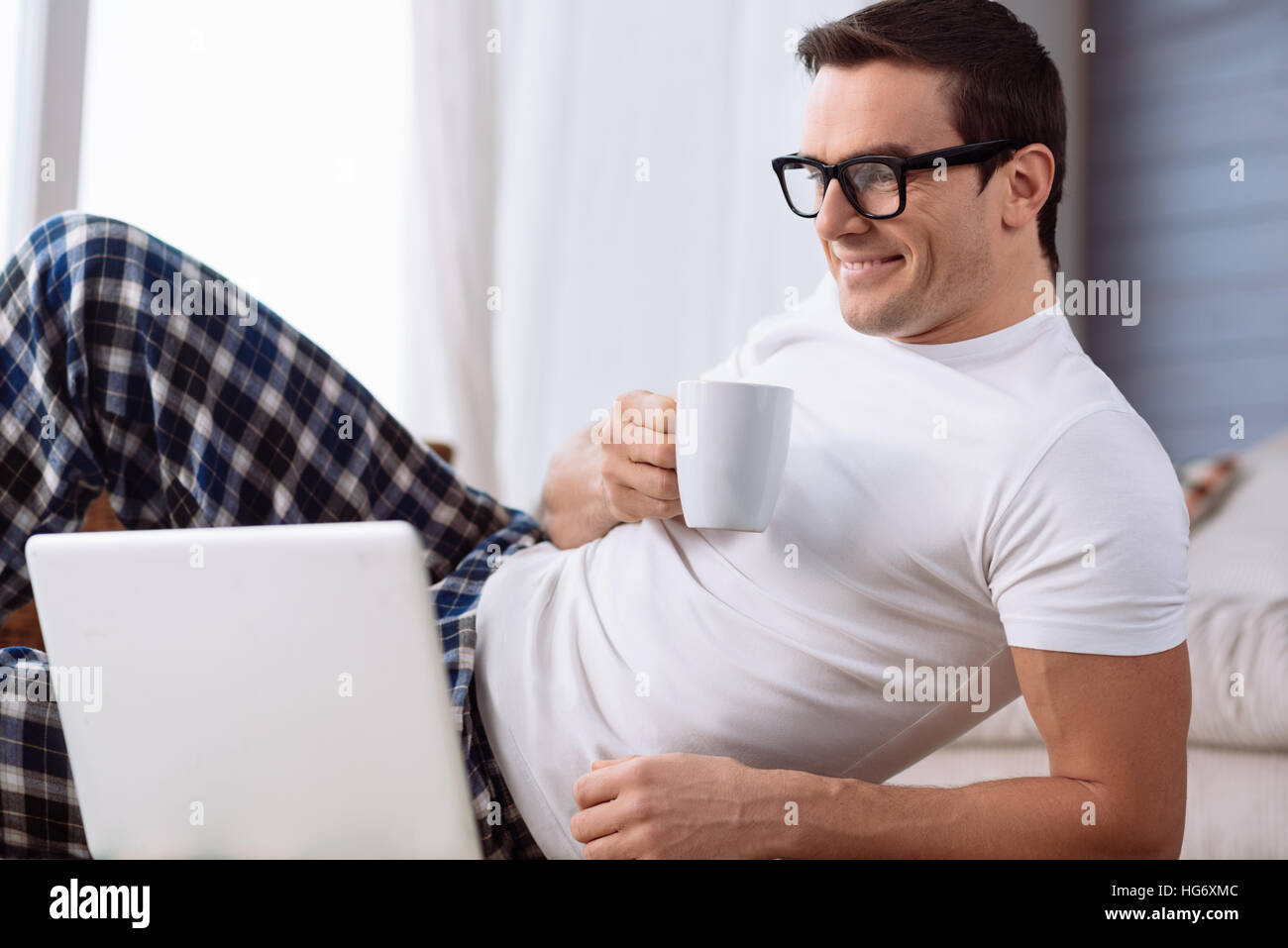 Delighted self employed man working on the computer Stock Photo - Alamy