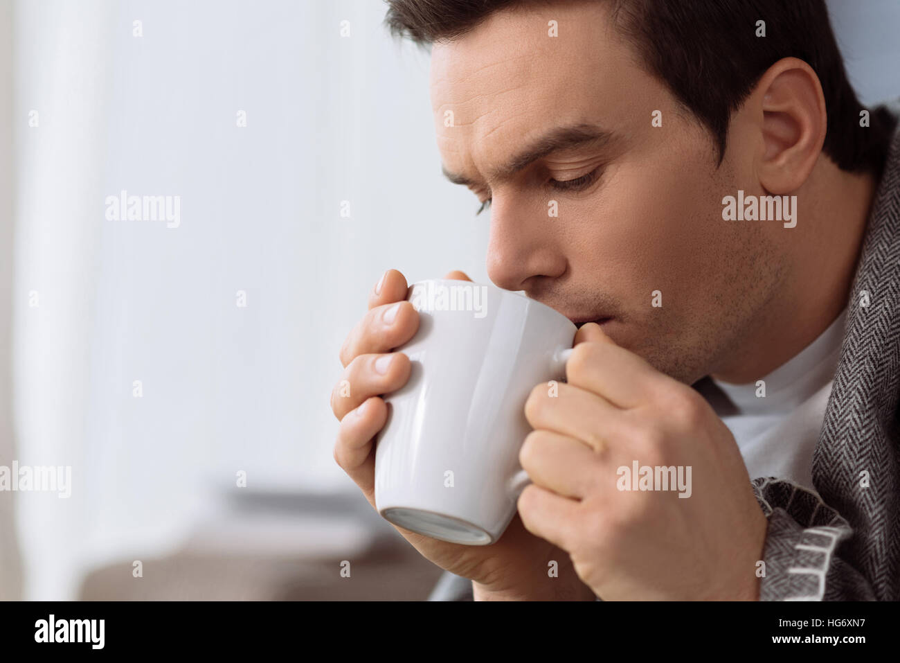 Handsome brunette man enjoying his tea Stock Photo - Alamy