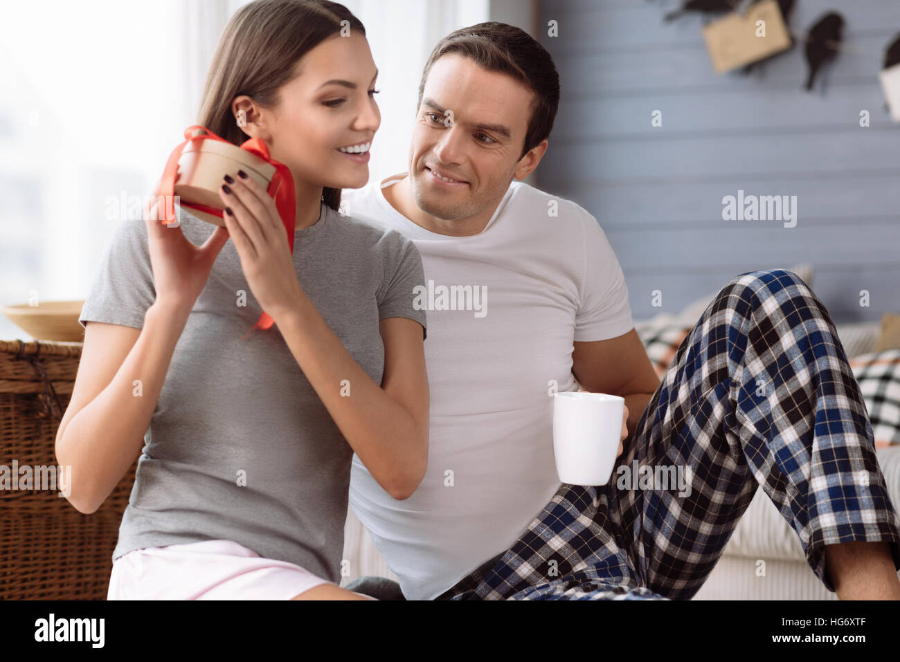 Curious happy woman shaking a gift box Stock Photo - Alamy