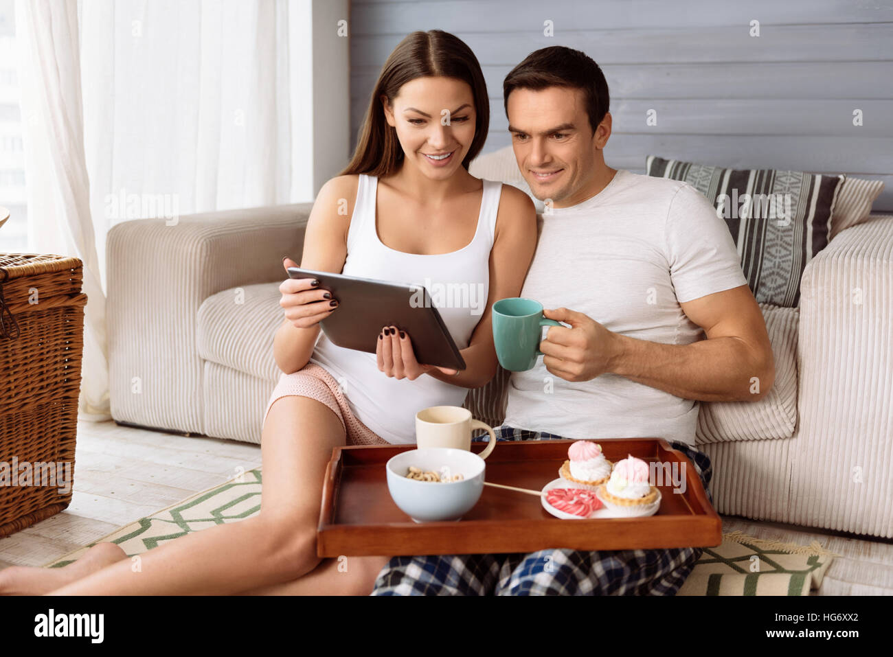 Pleasant attractive woman showing something on the tablet Stock Photo ...