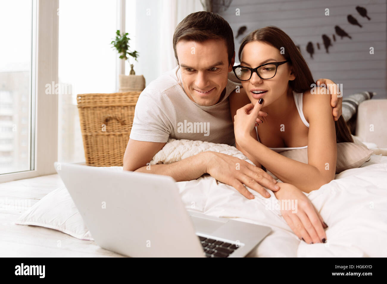 Happy nice couple looking at the laptop screen Stock Photo - Alamy