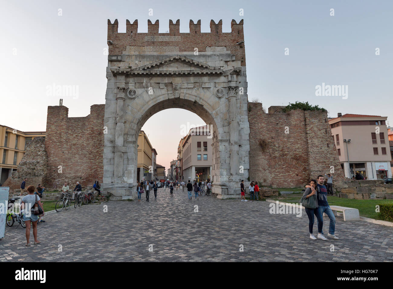 People walk in front of Arch of Augustus, ancient romanesque gate of ...
