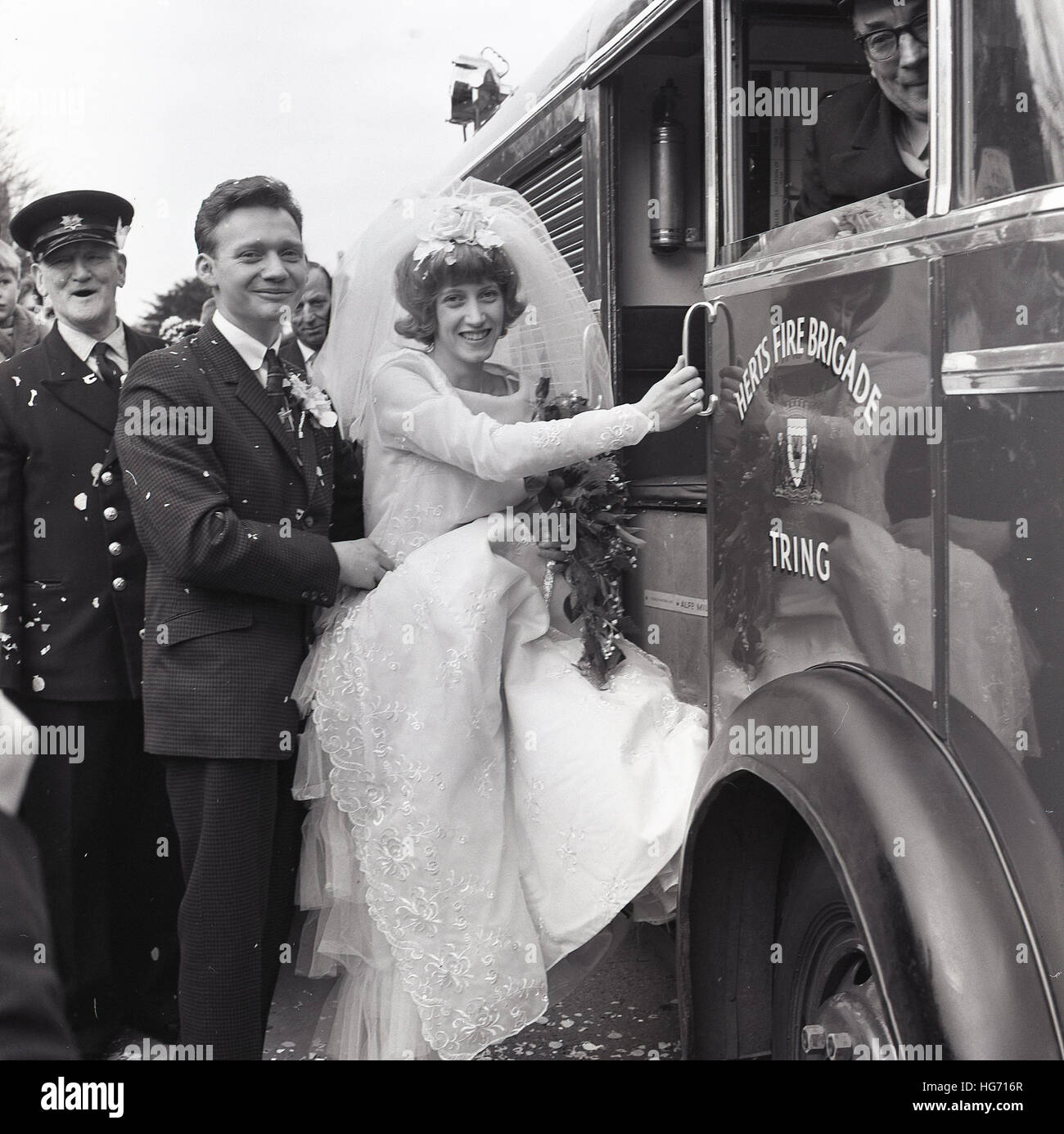 1960s, historical, just married couple climb aboard a fire engine ...