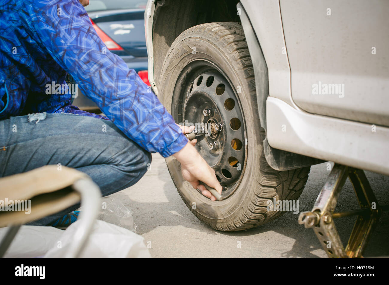 man changing a wheel on the road. on way there was breakage of wheel ...