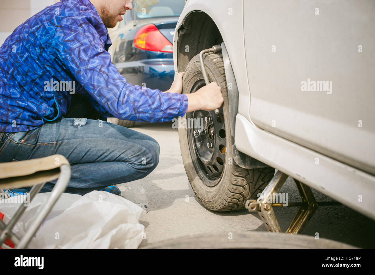 man changing a wheel on the road. on way there was breakage of wheel ...