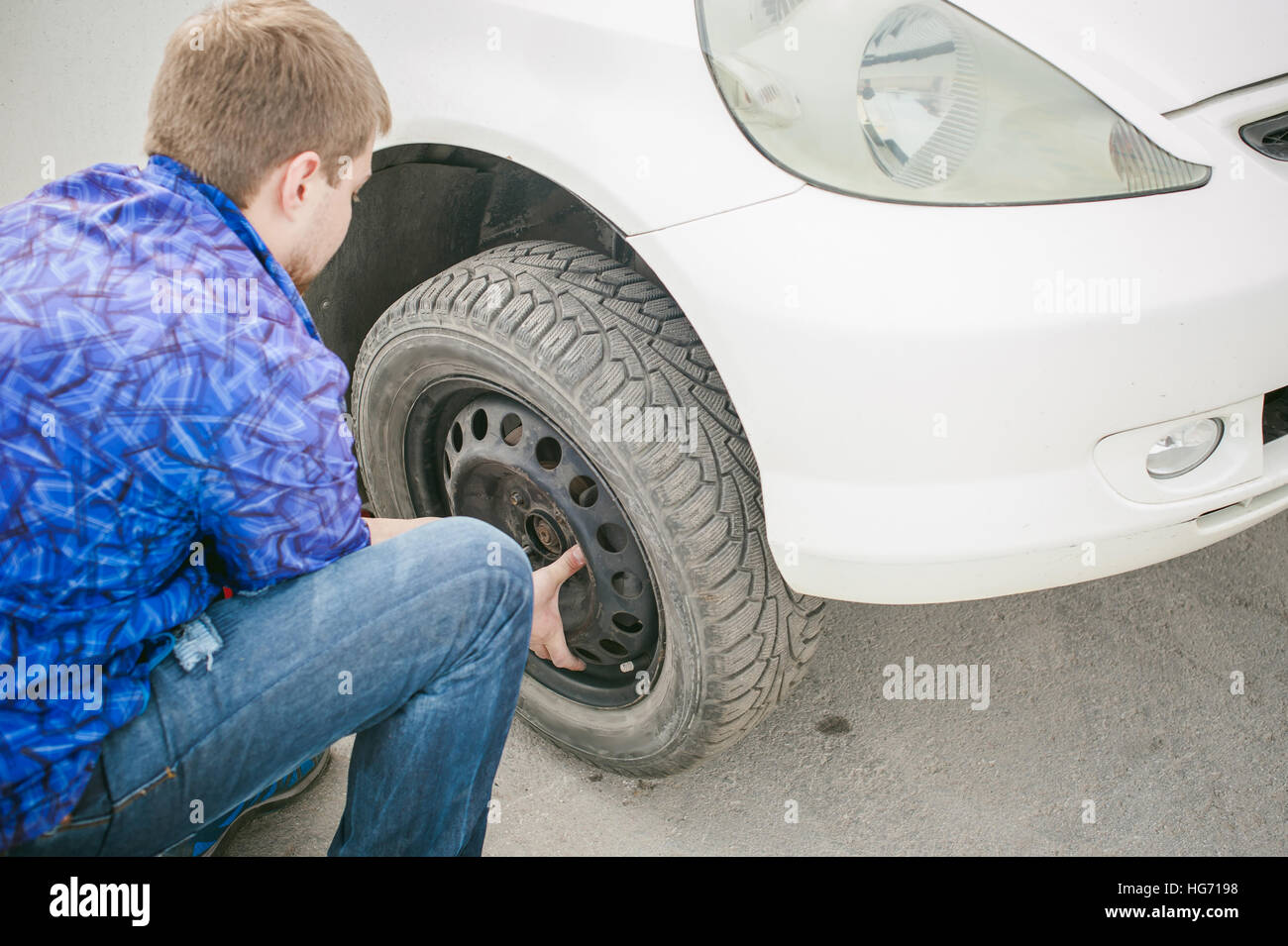 man changing a wheel on the road. on way there was breakage of wheel ...