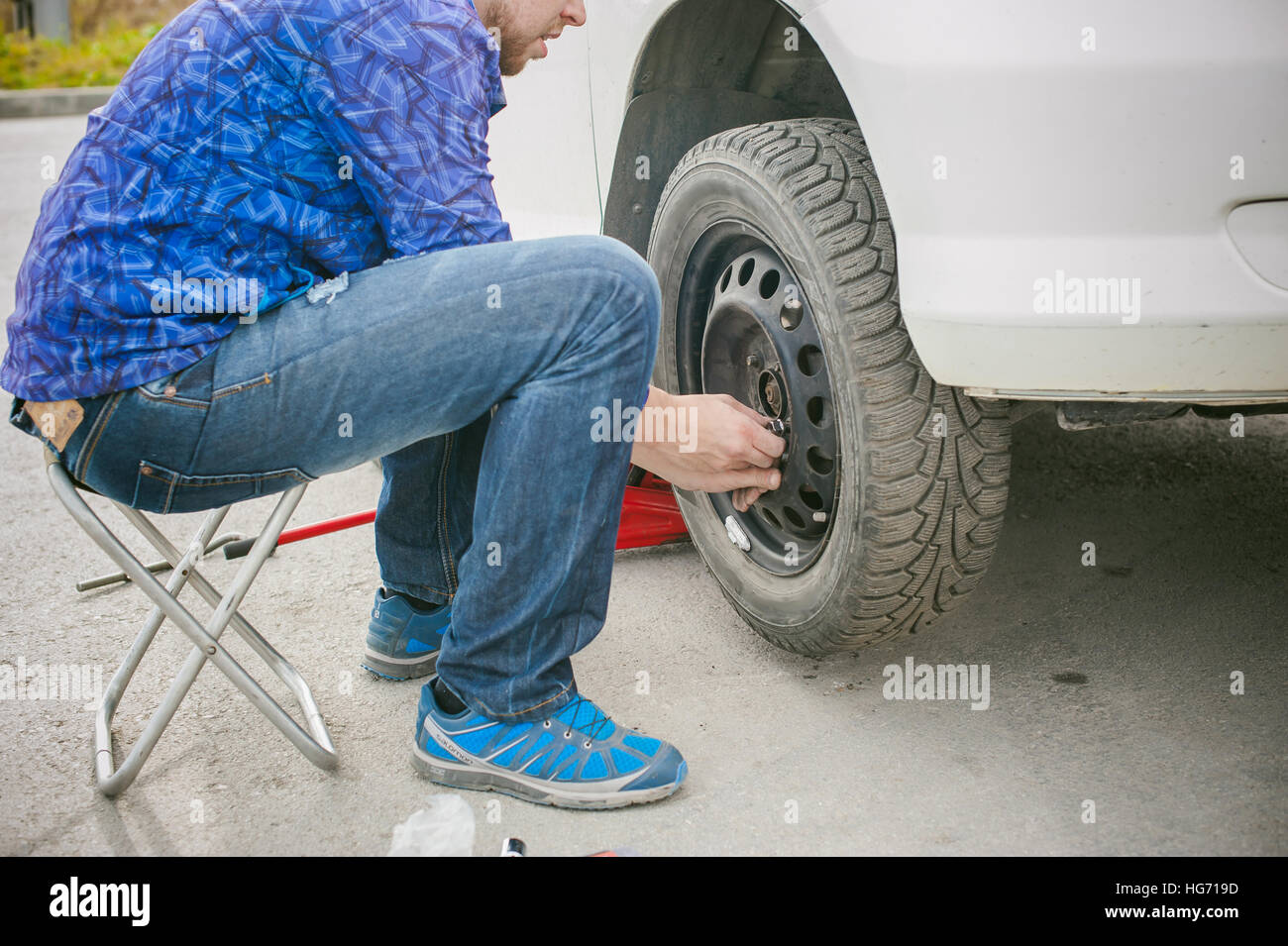 man changing a wheel on the road. on way there was breakage of wheel ...