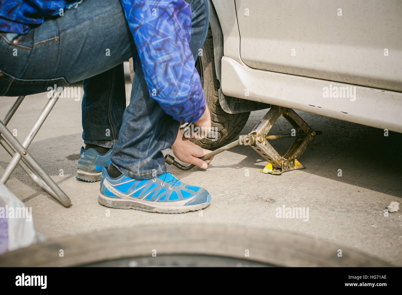 man changing a wheel on the road. on way there was breakage of wheel ...