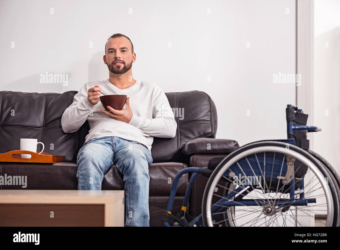 Young disabled man having breakfast Stock Photo - Alamy