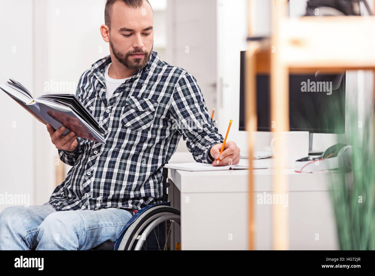Handsome responsible man writing down quotes Stock Photo - Alamy