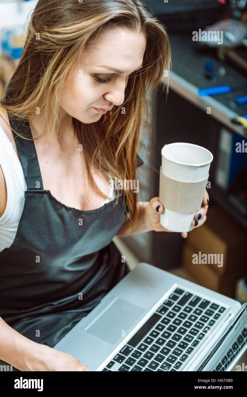 Pretty female mechanic relaxing after work in the garage Stock Photo ...