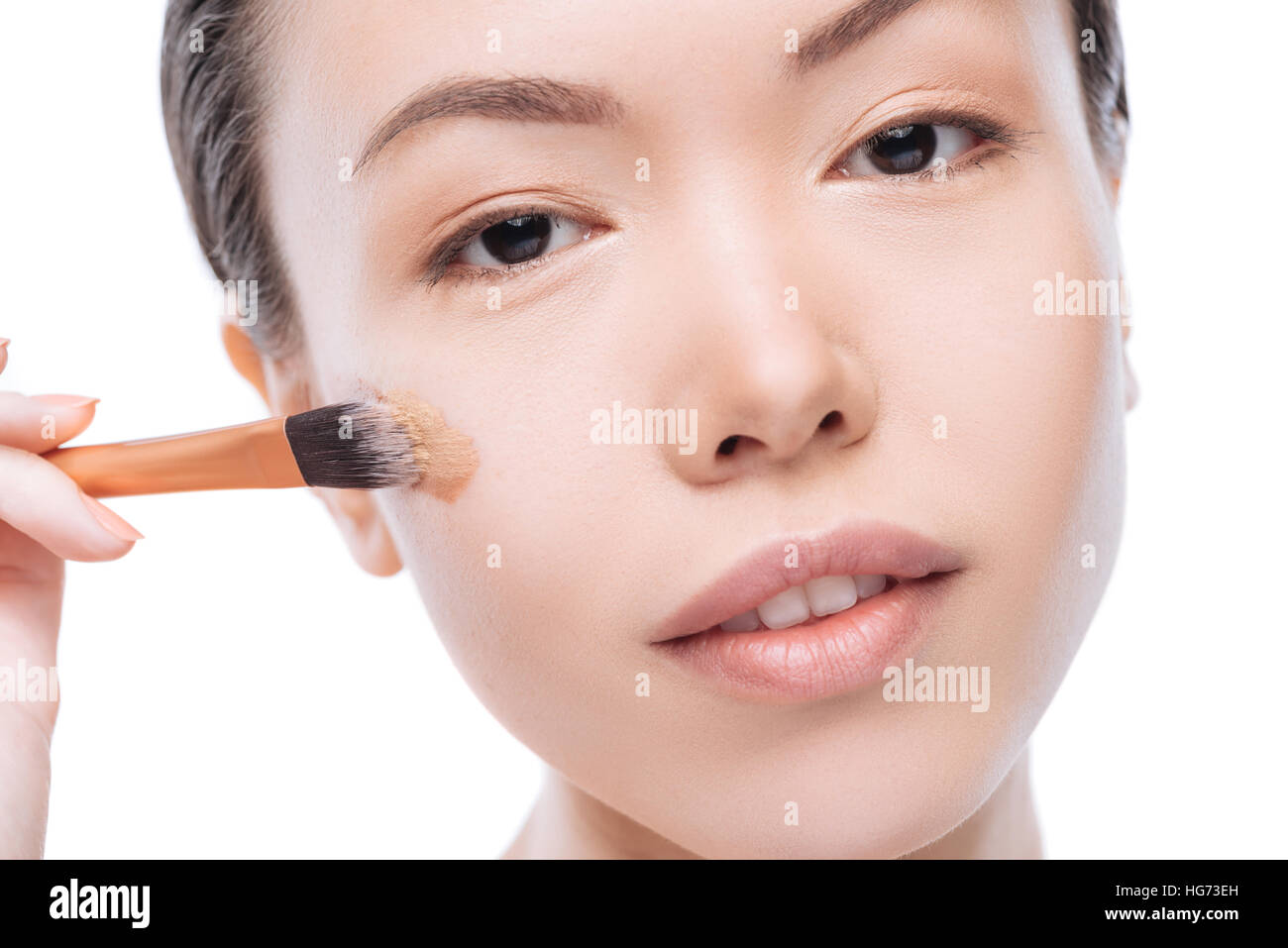 Pretty good looking woman using a cosmetic brush Stock Photo - Alamy