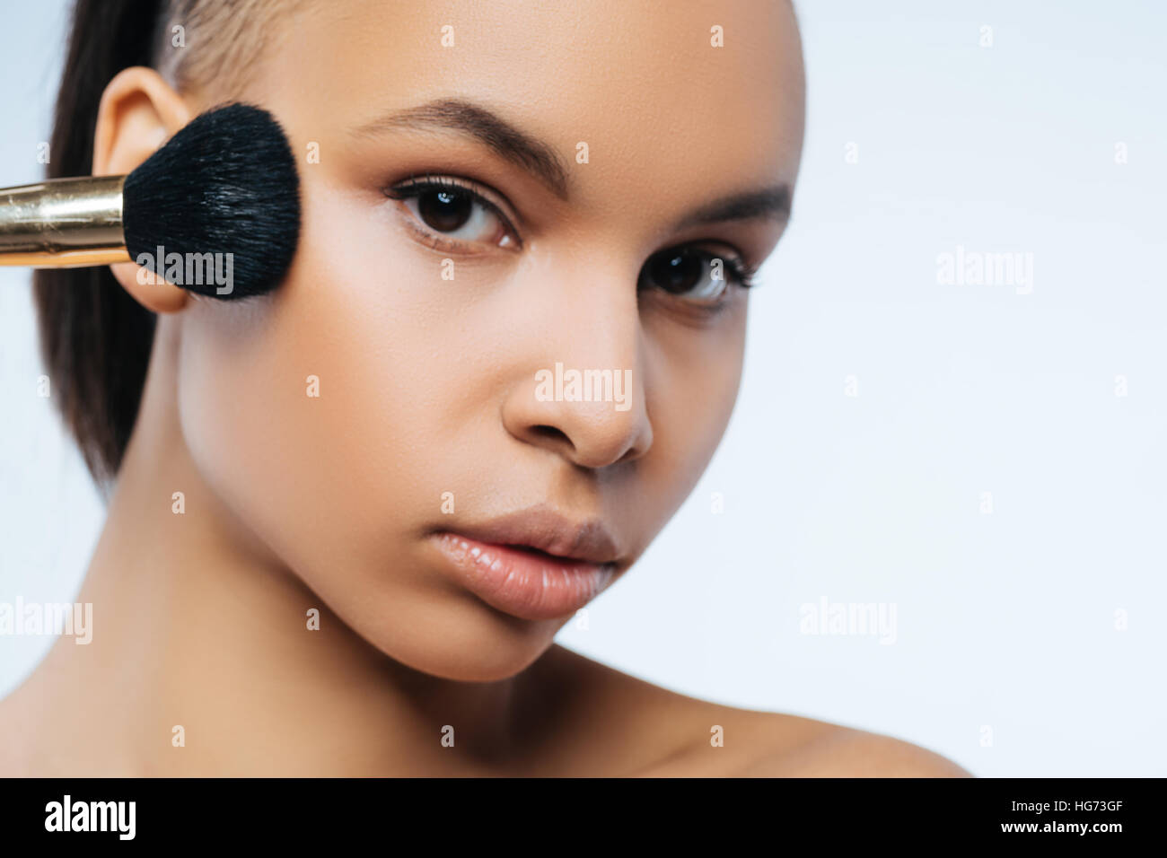 Cute good looking woman using a cosmetic brush Stock Photo - Alamy