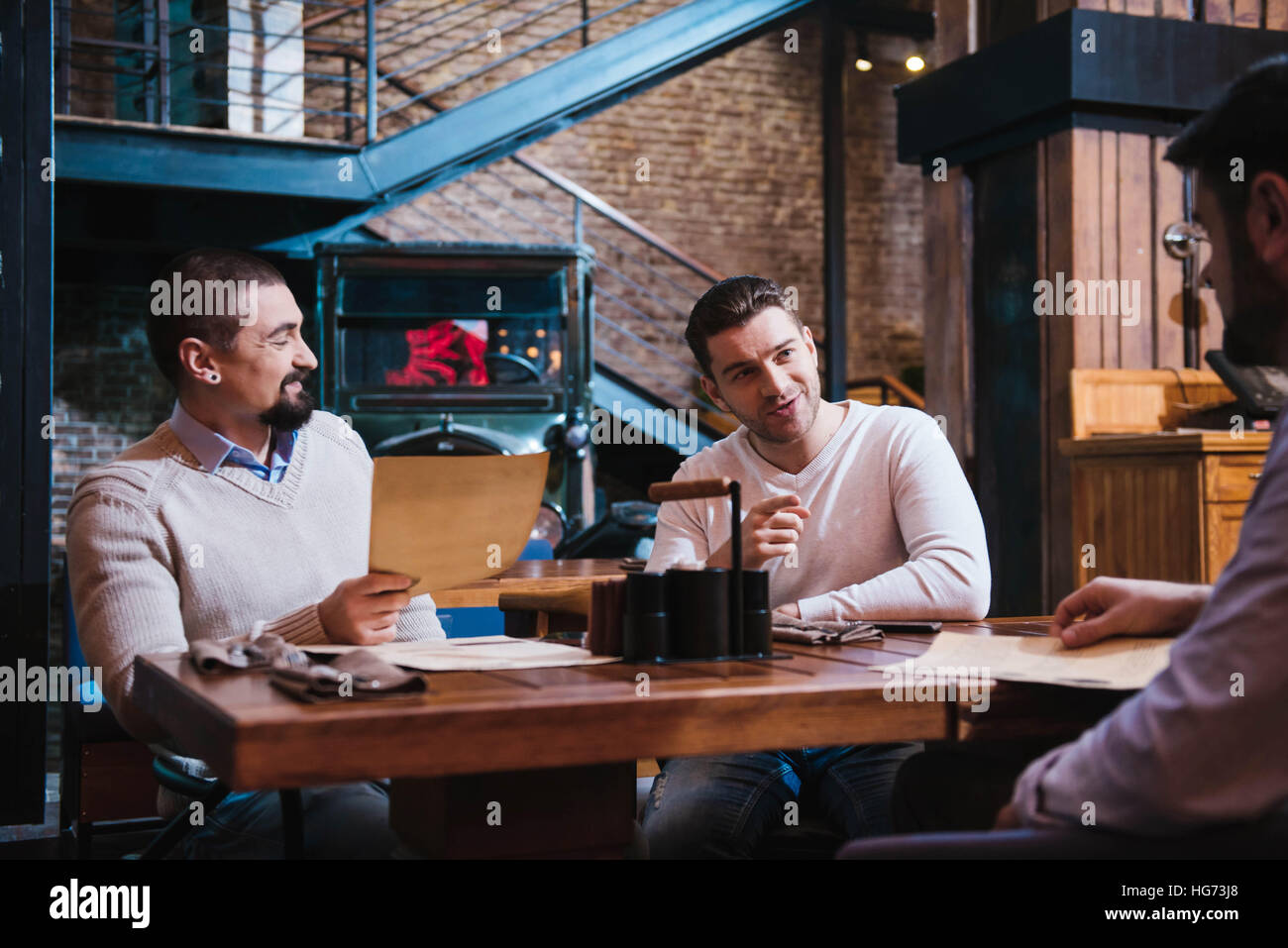 Pleasant nice man pointing at his friend Stock Photo - Alamy