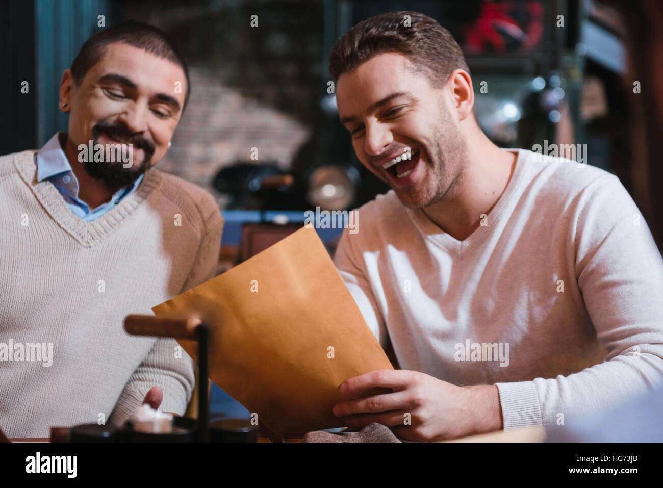 Happy handsome men looking at the menu Stock Photo - Alamy