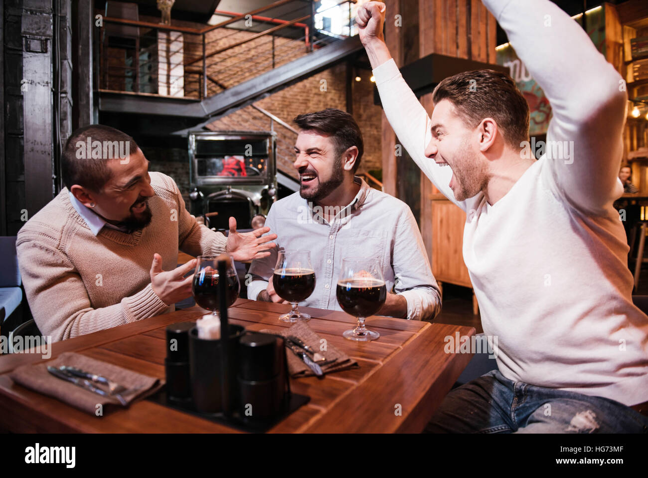 Joyful positive man cheering with his friends Stock Photo - Alamy