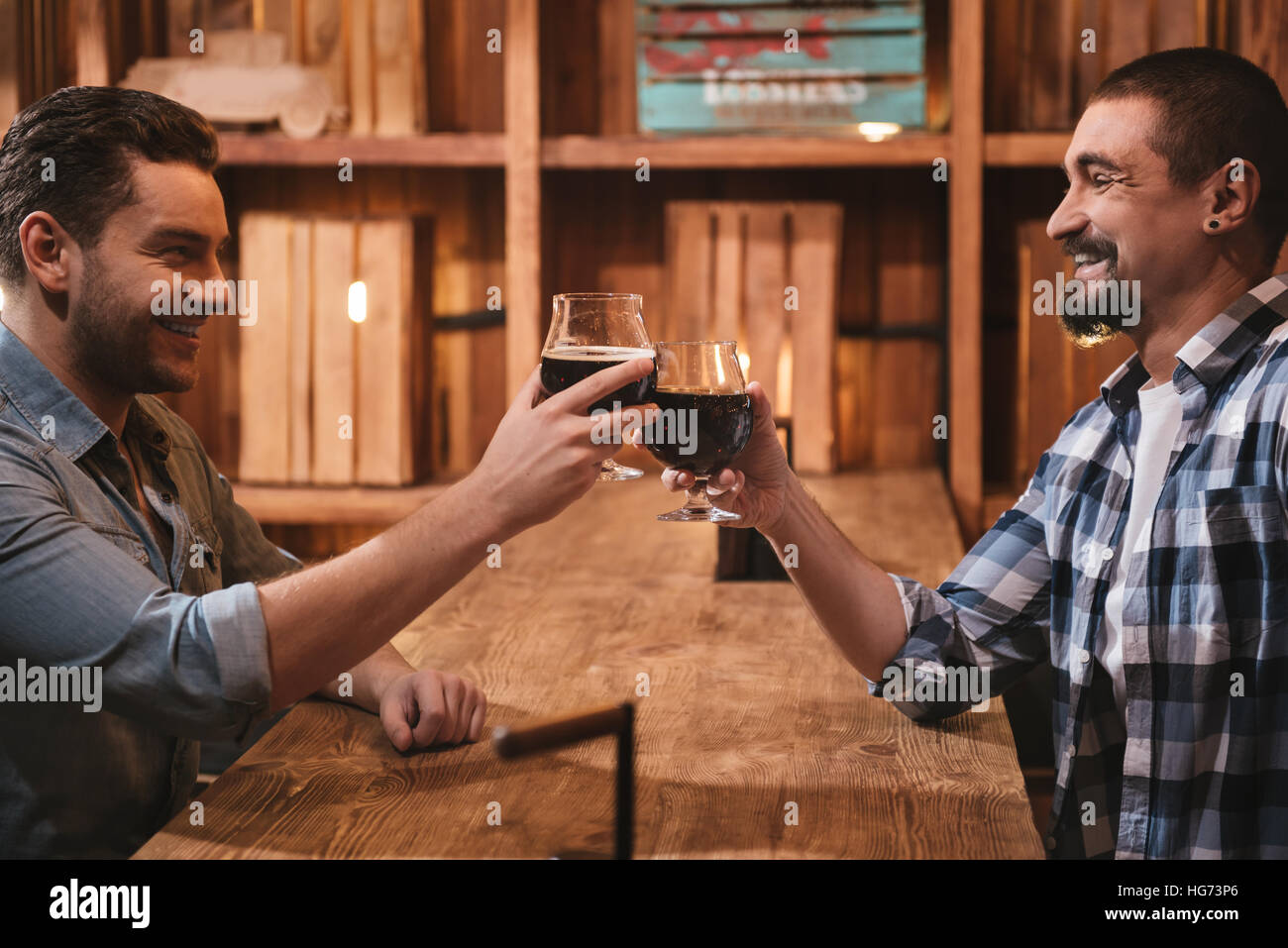 Positive male friends sitting opposite each other Stock Photo - Alamy