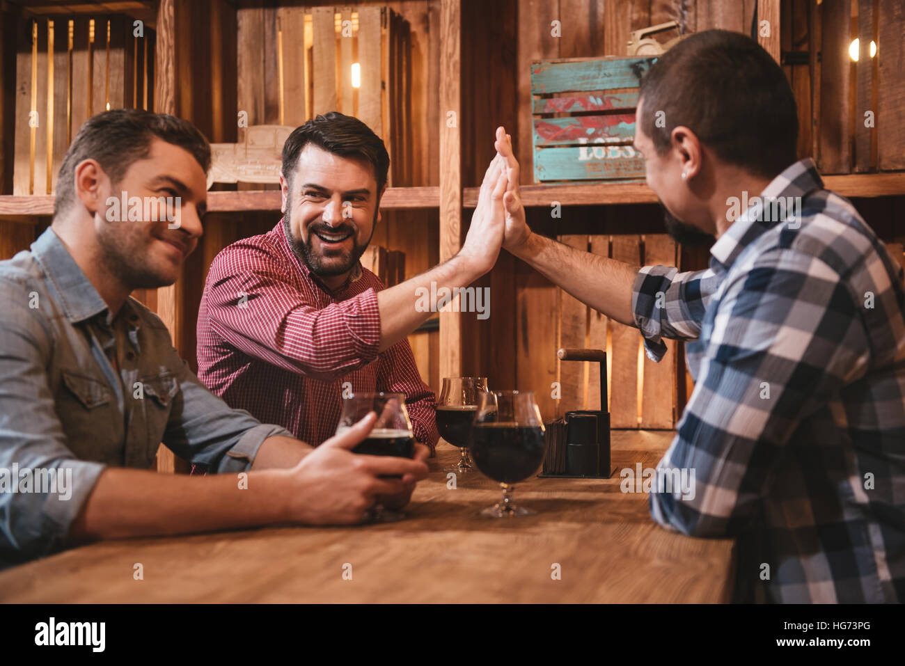 Handsome cheerful friends giving high five Stock Photo - Alamy