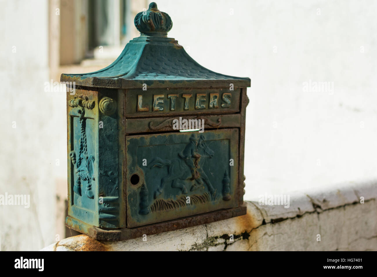 An old rusty blue letterbox sitting on a white wall Stock Photo - Alamy