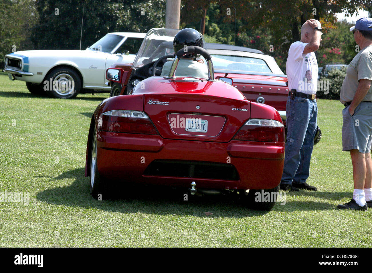 Man driving a one-man shiny red car Stock Photo - Alamy