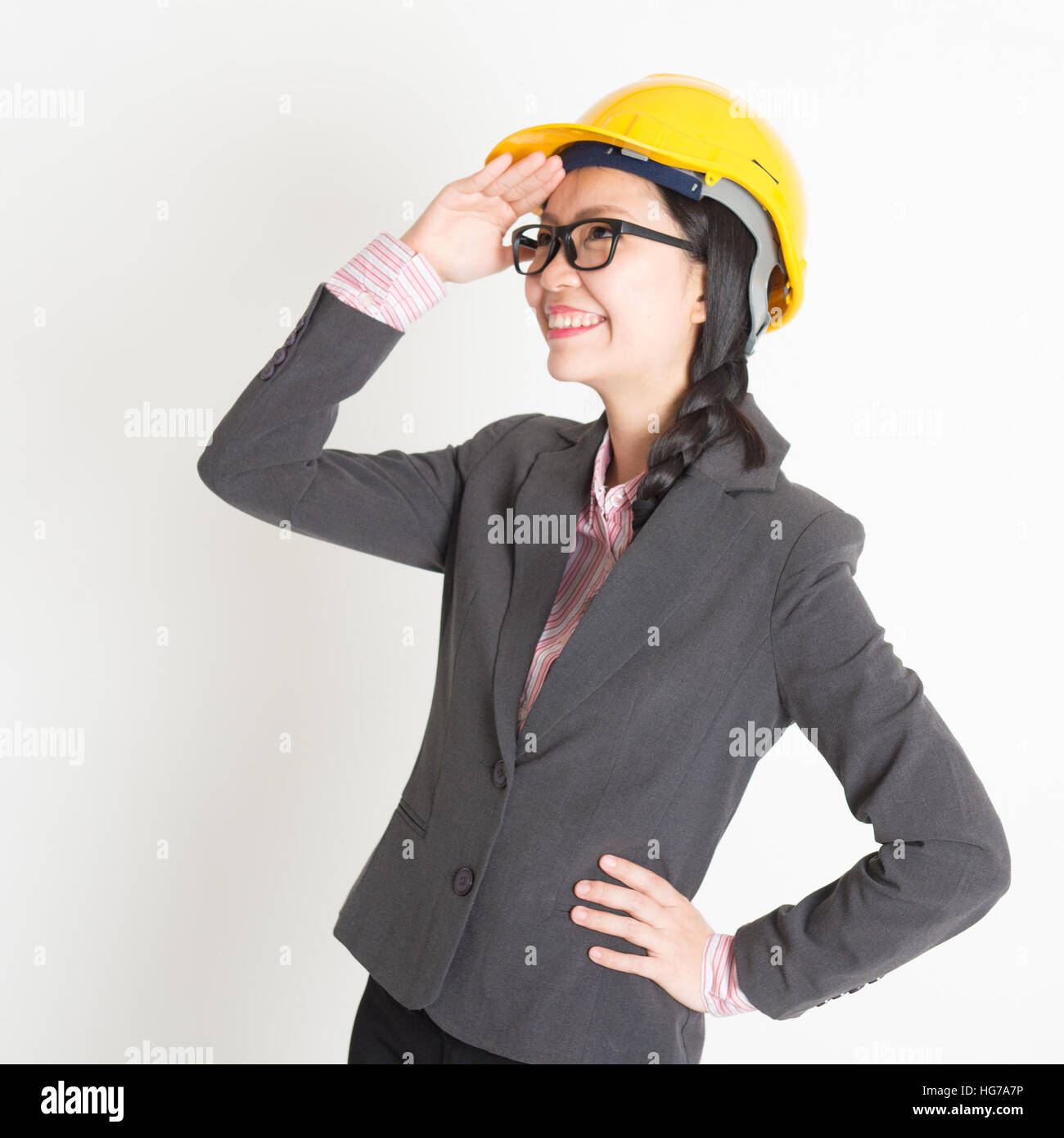 Portrait of Asian female engineer with hard hat hand shielding and ...