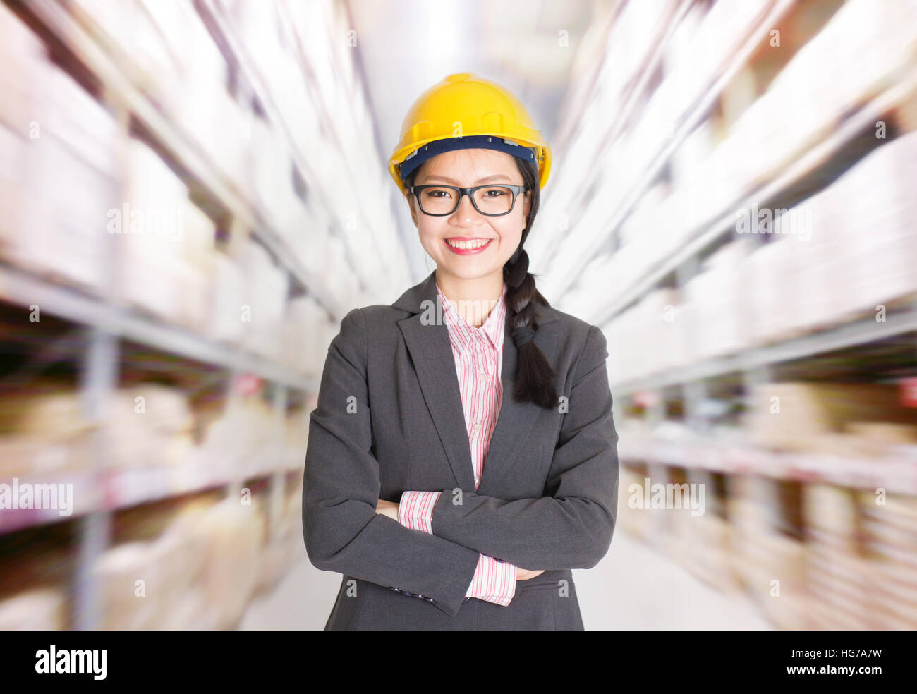 Young Asian female store manager with hard hat arms crossed standing in ...