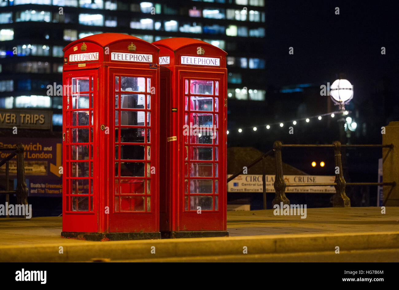 British bright red telephone call box lit up in the dark at night on ...