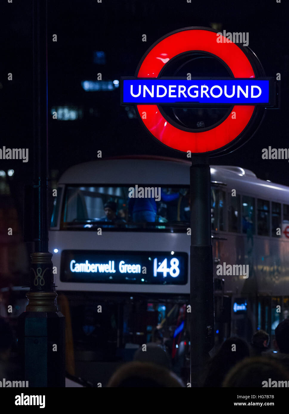 Illuminated London underground roundel tube sign at night with a London ...