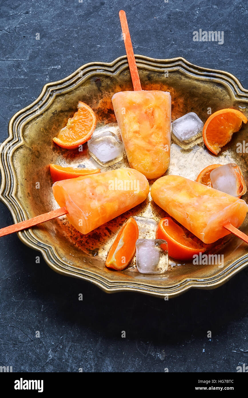 Tasty ice cream with tangerines in copper dish Stock Photo - Alamy