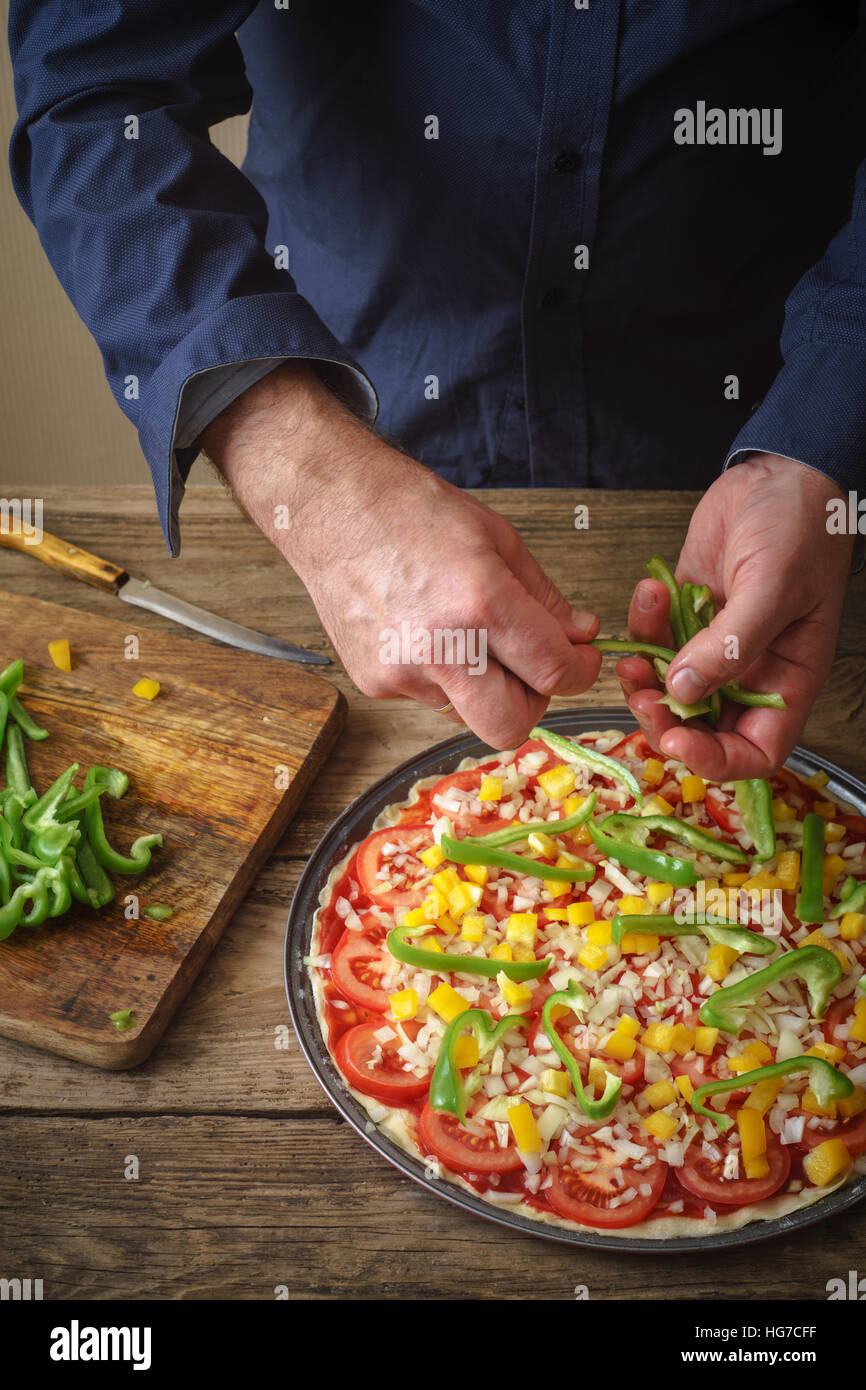 Man makes homemade pizza on the table vertical Stock Photo - Alamy