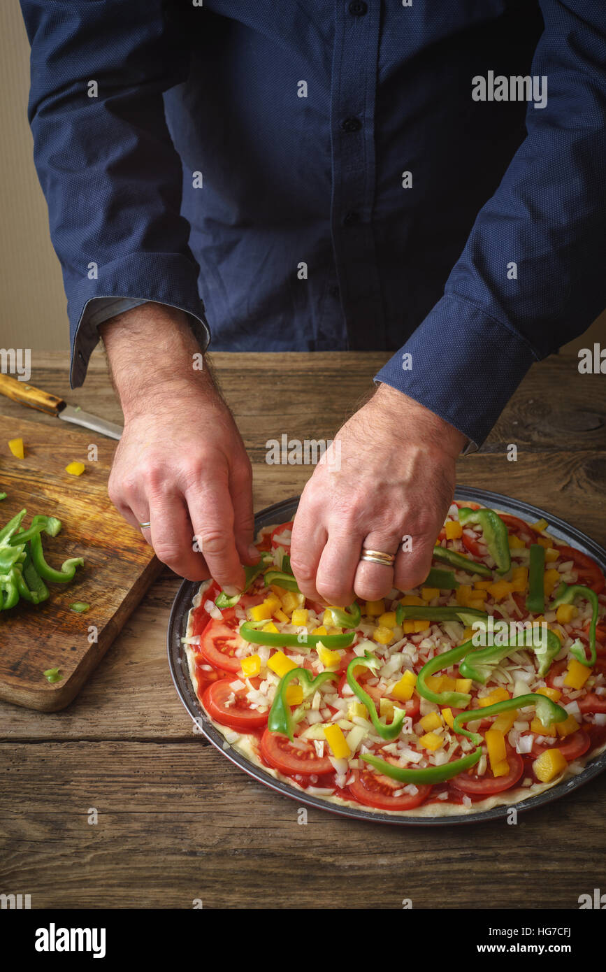 Man makes homemade pizza in the kitchen vertical Stock Photo - Alamy