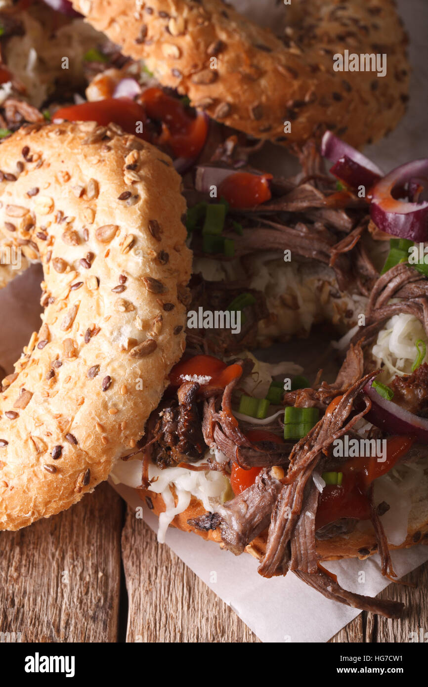 Bagel with vegetables and Pulled pork close-up on the table. vertical ...