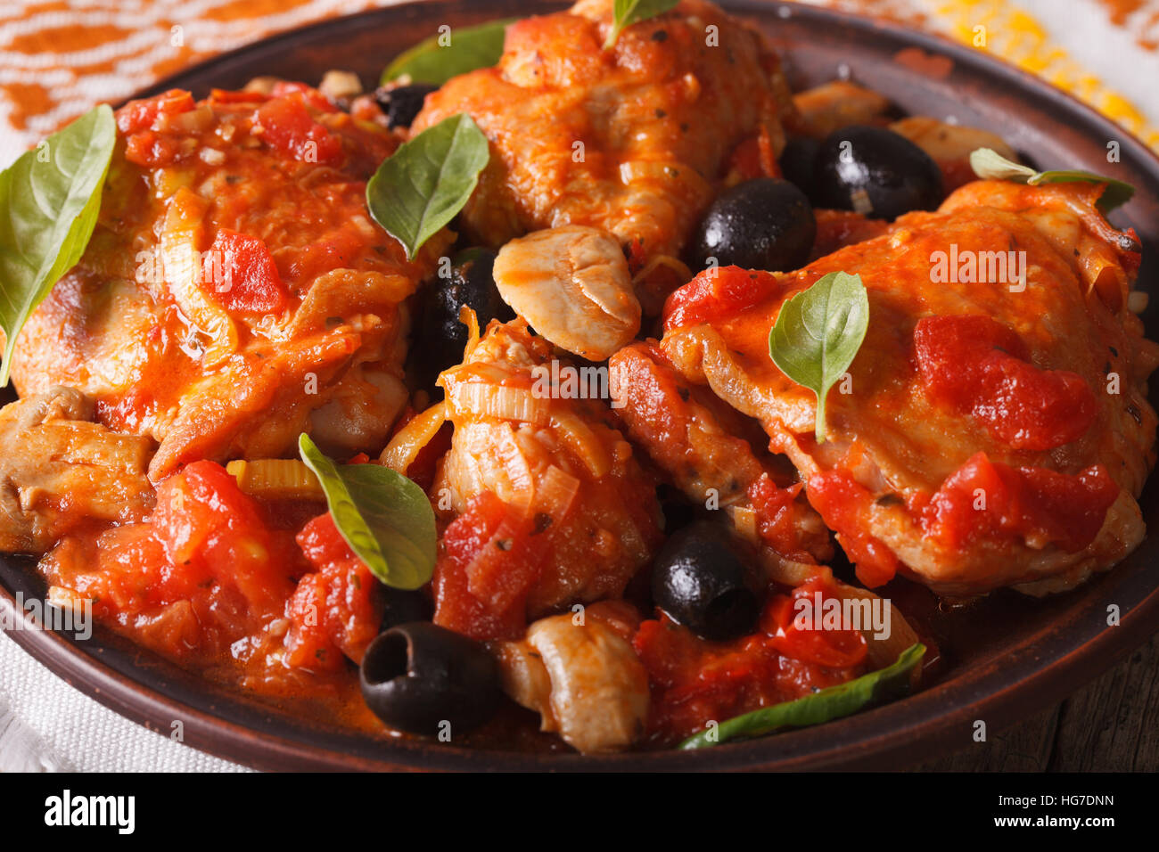 Italian food: Chicken Cacciatori with basil on a plate close-up ...