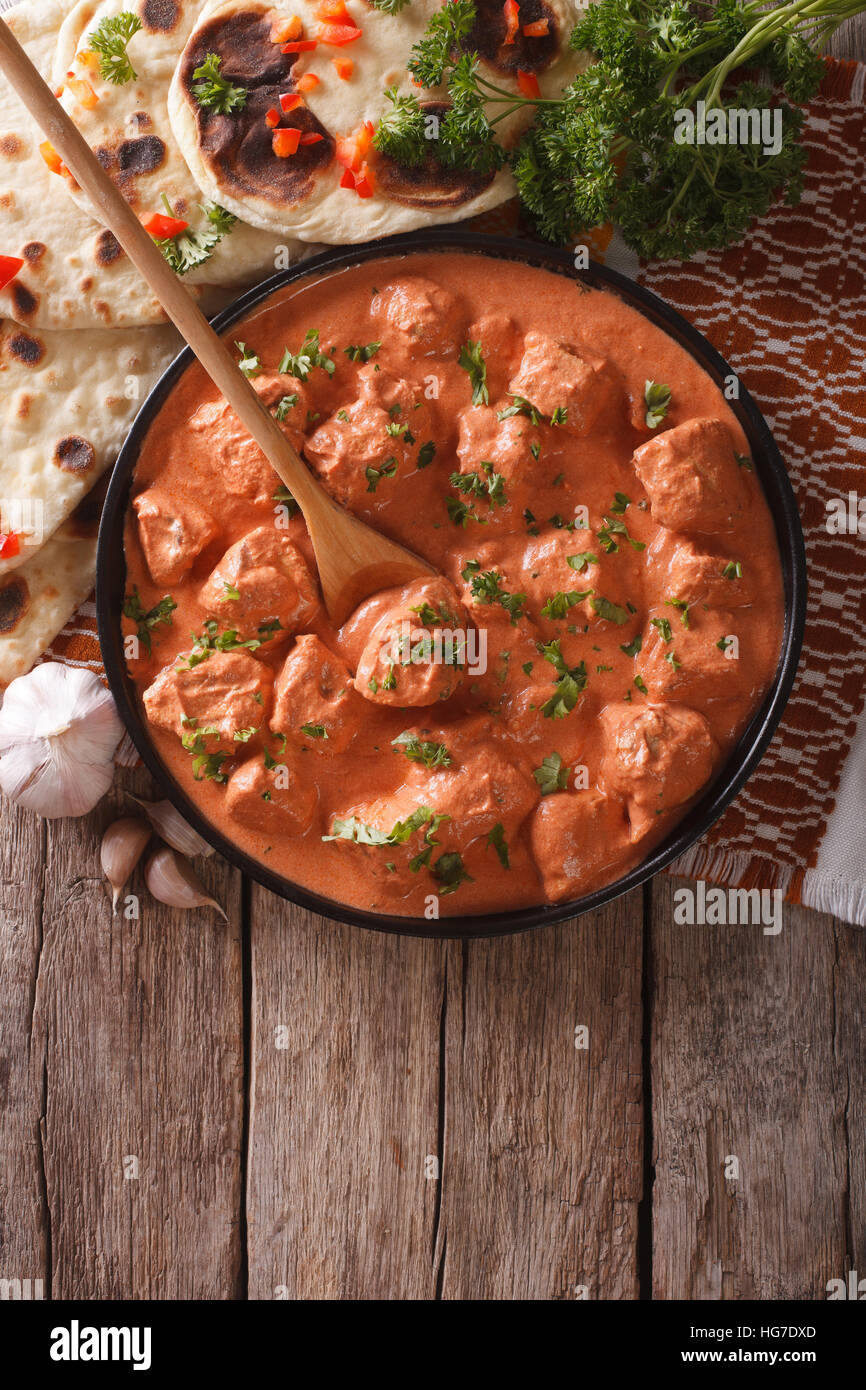 Indian tikka masala chicken and naan flat bread on the table. vertical ...