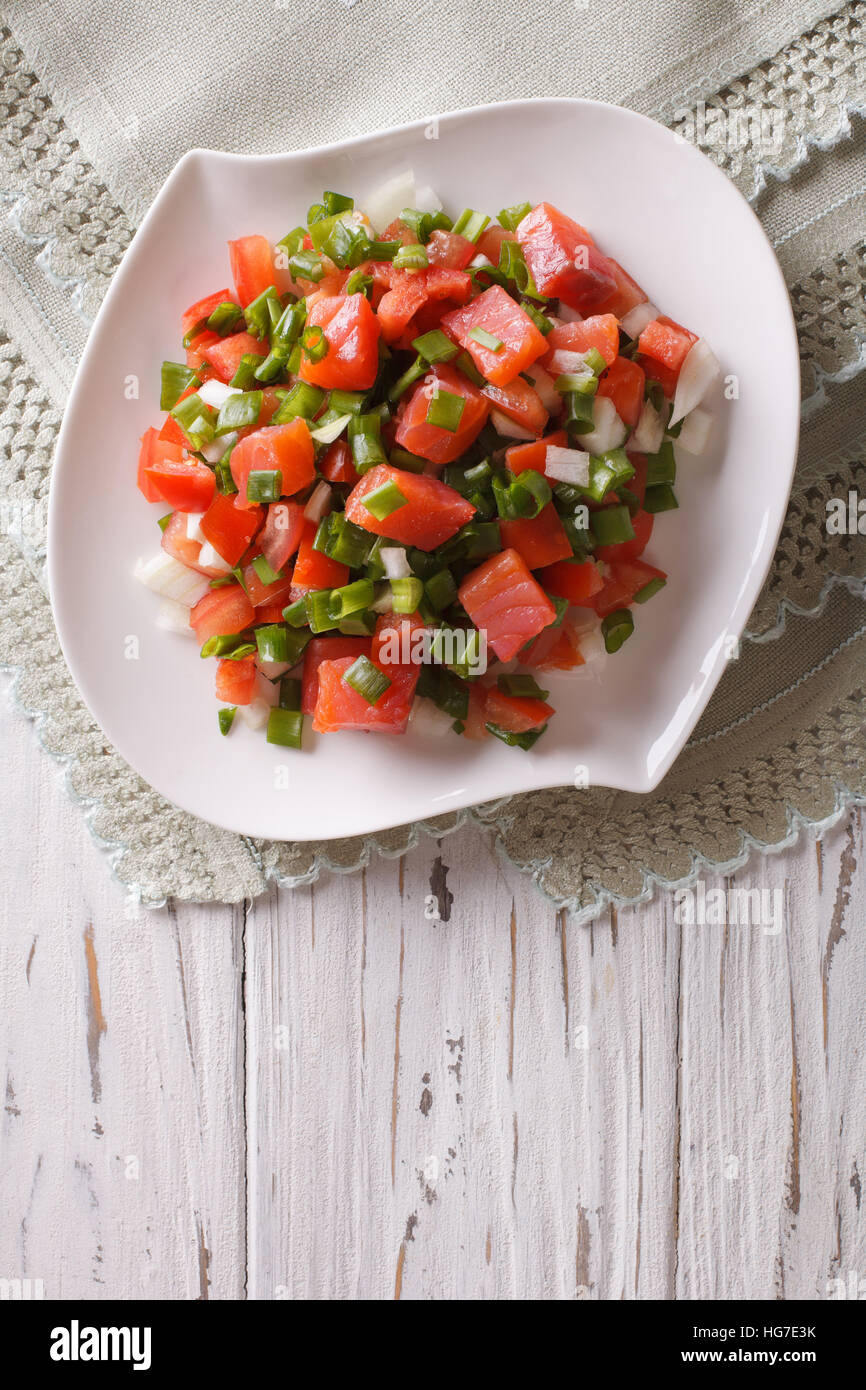 Hawaiian lomi lomi salad close-up on a plate on the table. vertical top ...