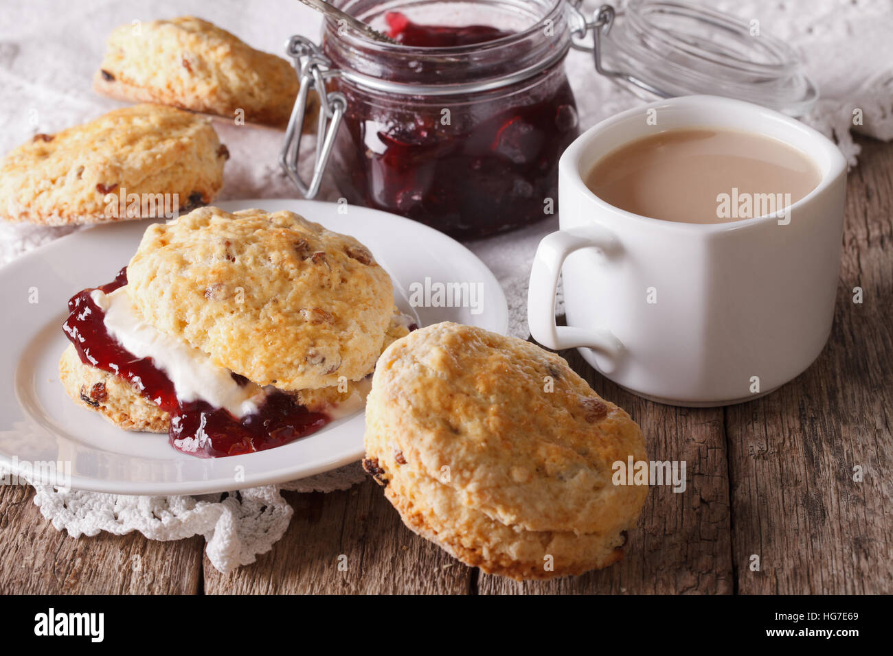 Scones with jam and tea with milk close-up on the table. horizontal ...