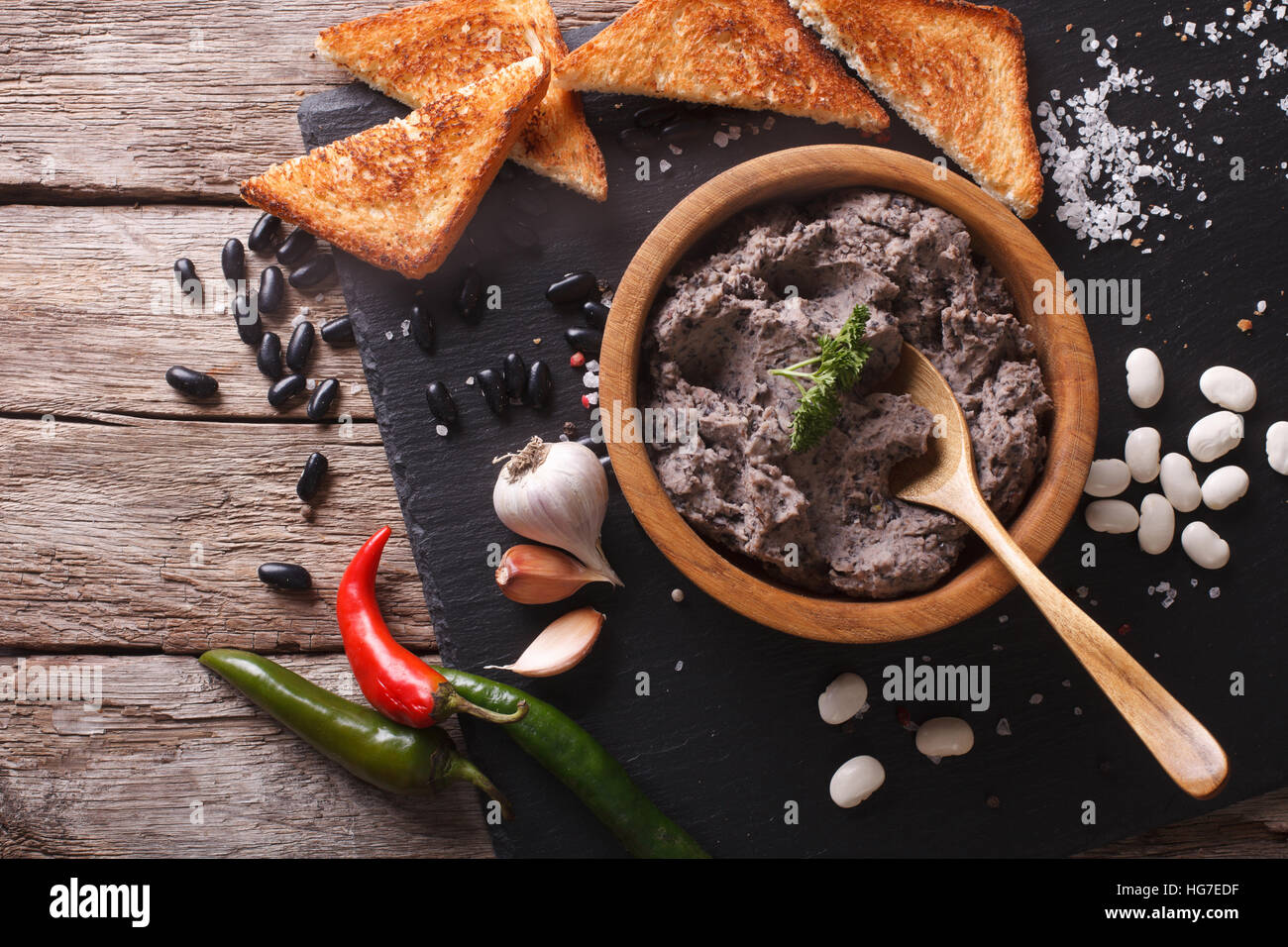 Frijoles refritos with ingredients on a table close-up. horizontal view ...