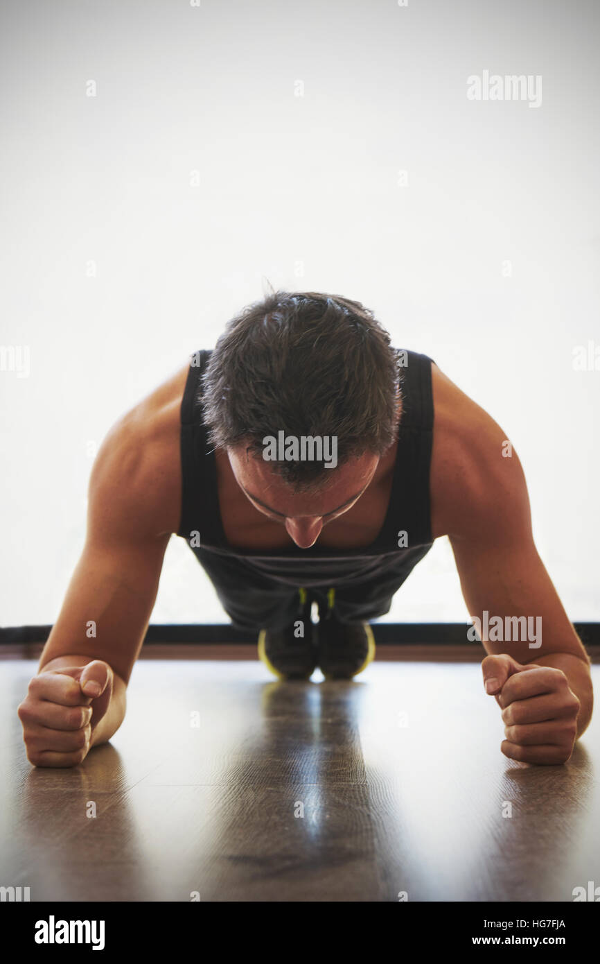 Fit young man doing pushups in a gym Stock Photo - Alamy