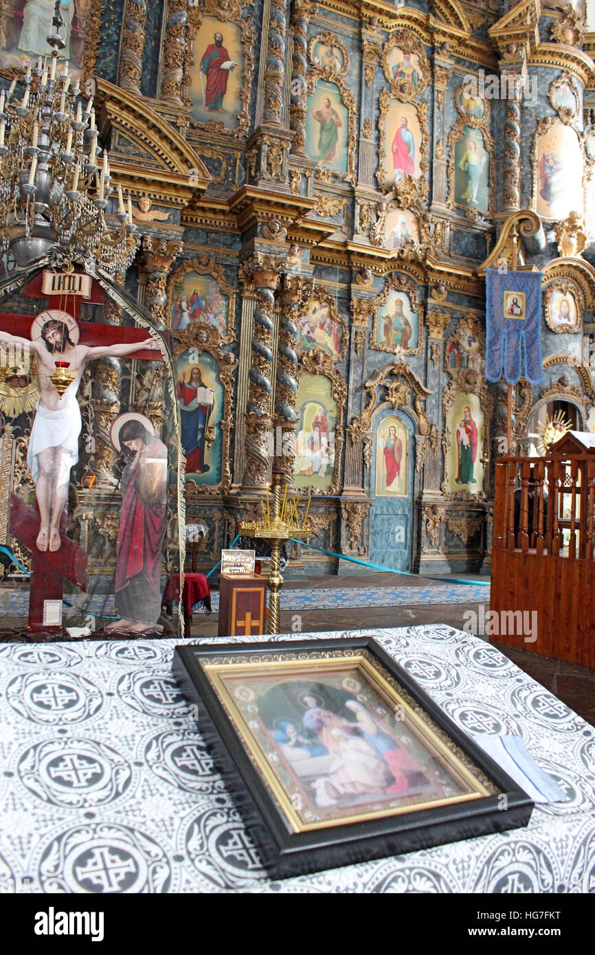 icon lies on the table by beautiful iconostasis with ancient icons set in wooden frame ...