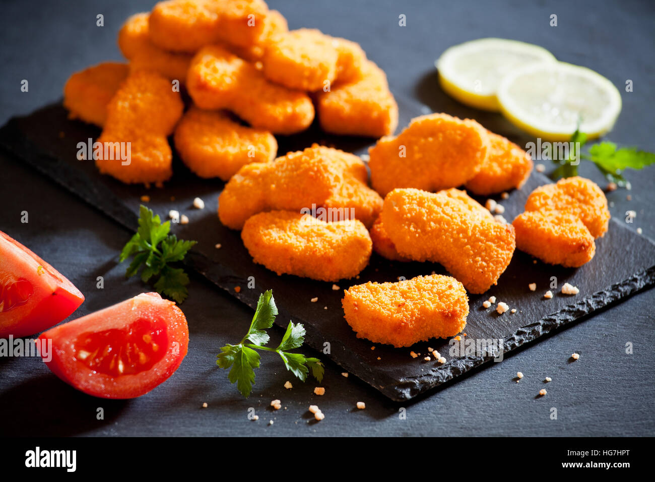 Bunch of tasty chicken nuggets on a slate plate Stock Photo - Alamy
