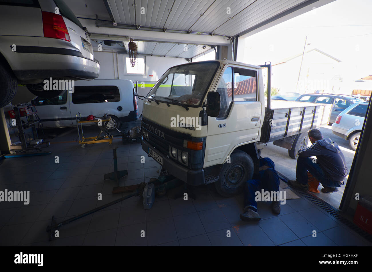 Mechanic fixing a Toyota flat bed van in a workshop Stock Photo - Alamy