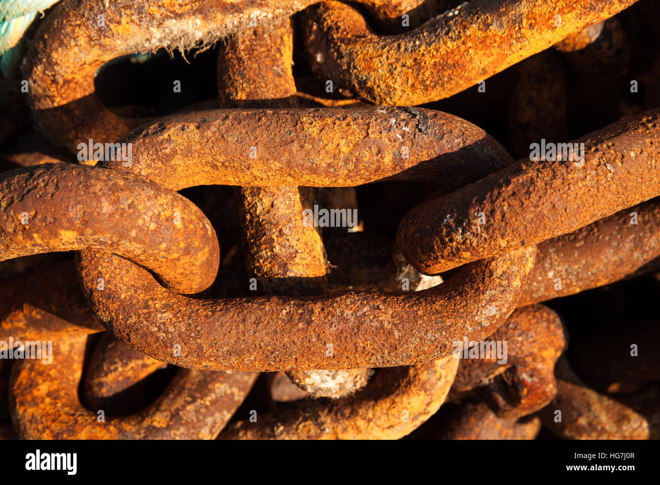 Big iron chains from an old ships anchor rusting by the harbor side ...