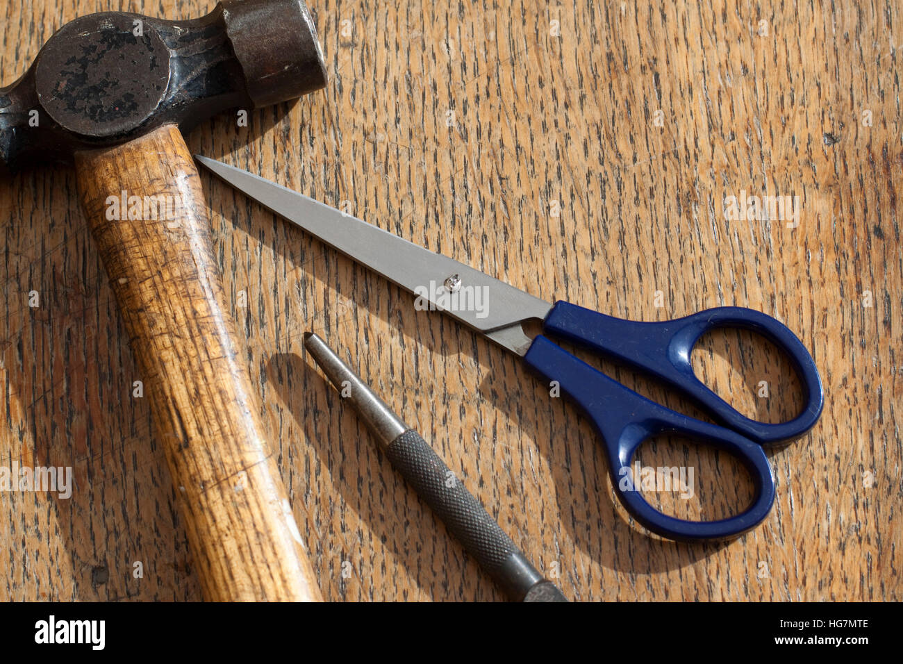 Ball pein hammer, scissors and a centre/centrer punch on a wooden ...