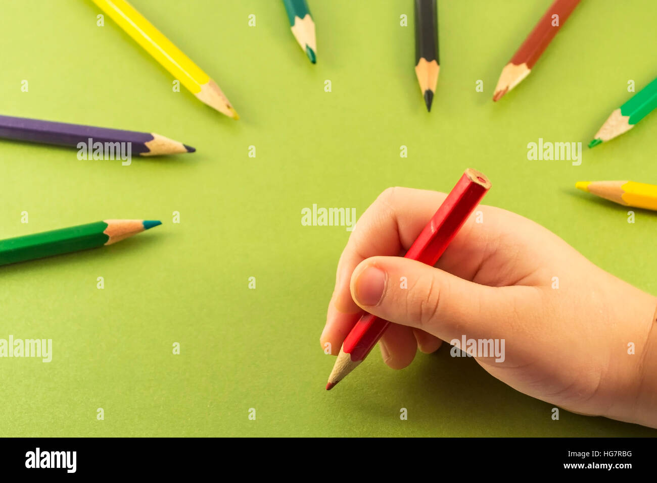 Kids hand holding a red pencil Stock Photo - Alamy