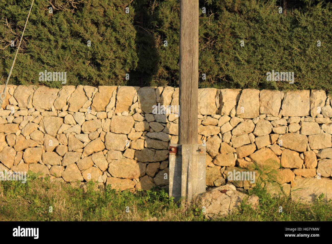 Beautiful drystone wall, hedging, and the base of a telephone poll with ...