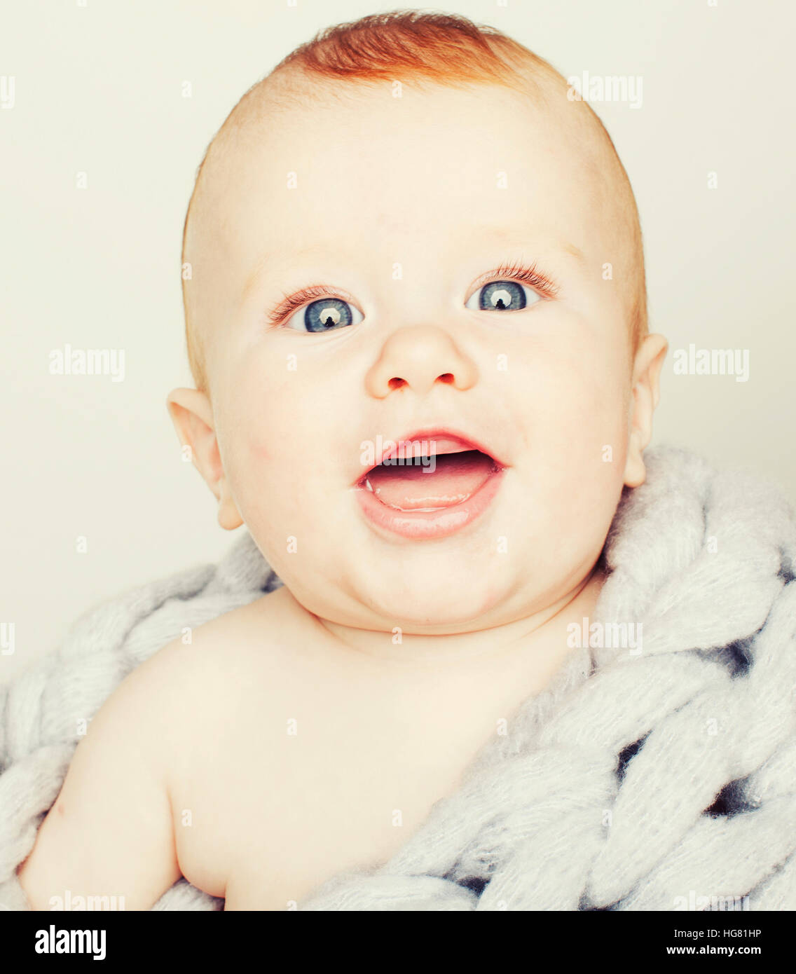 little cute red head baby in scarf all over him close up isolate Stock ...