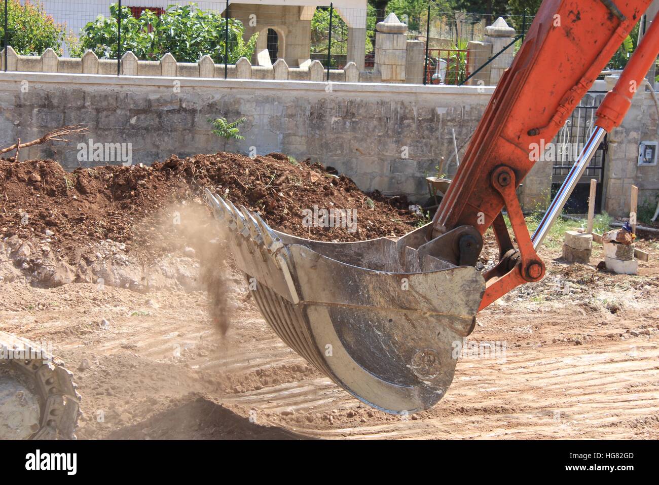 The bucket of a back hoe machine smooths dry earth into place Stock ...