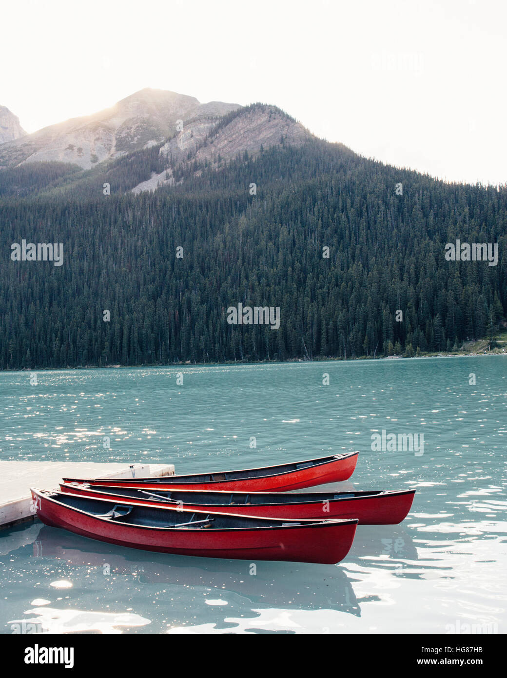 Canoe moored in lake by mountain against clear sky Stock Photo - Alamy